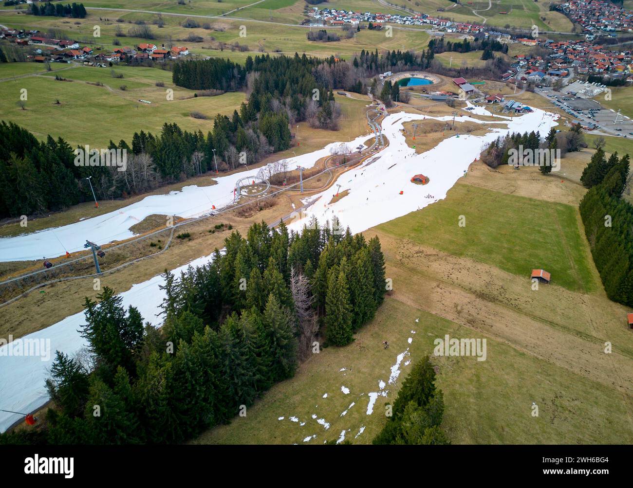 Alpine skiing on the ski slope in warm temperatures and lack of snow at ...