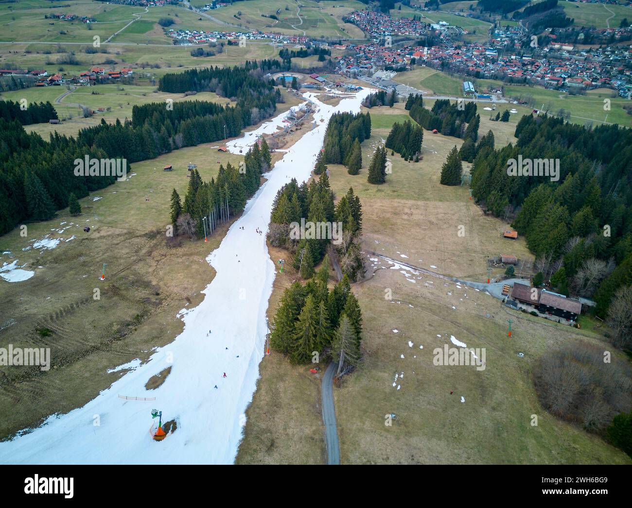 Alpine skiing on the ski slope in warm temperatures and lack of snow at ...