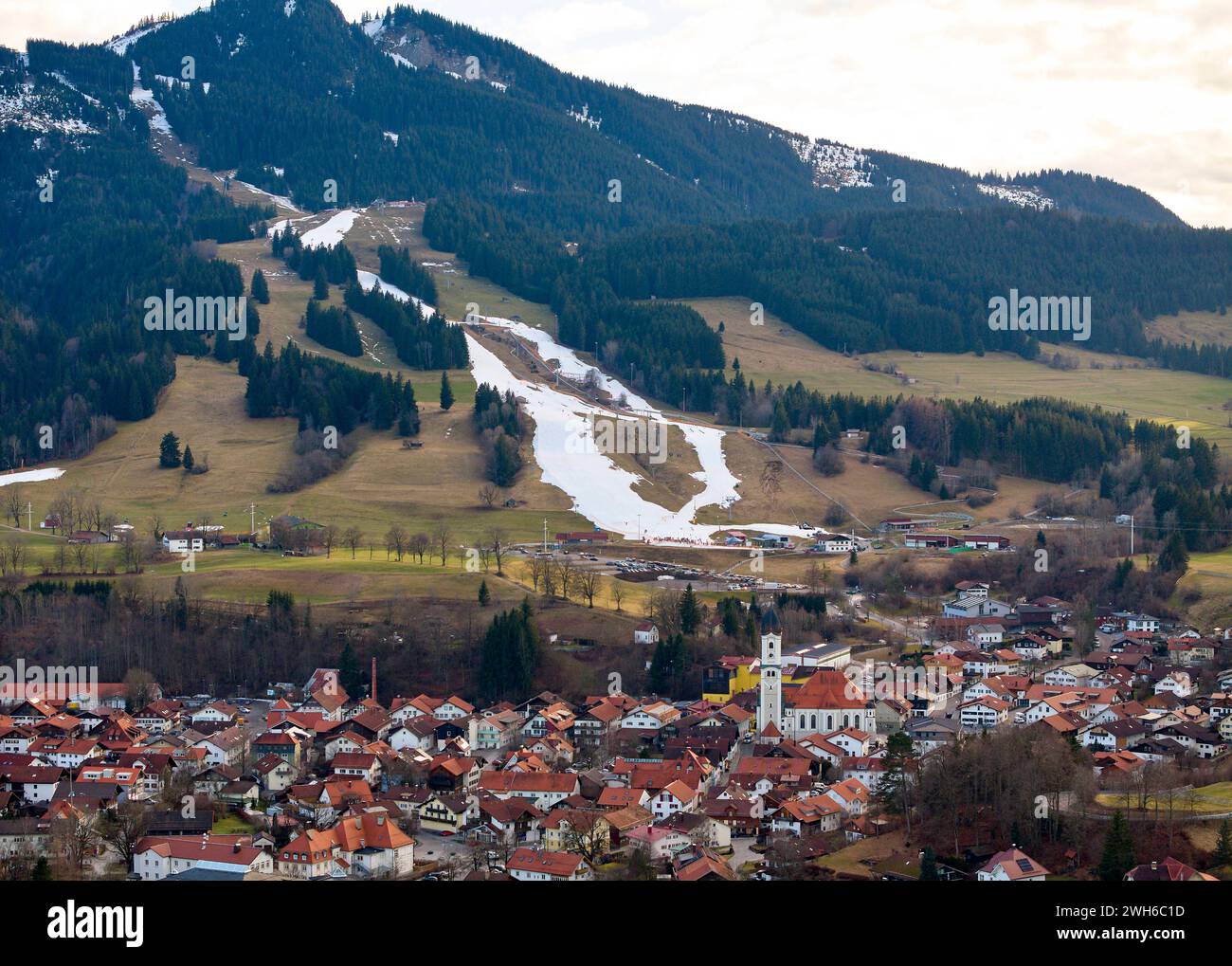 Alpine skiing on the ski slope in warm temperatures and lack of snow at ...