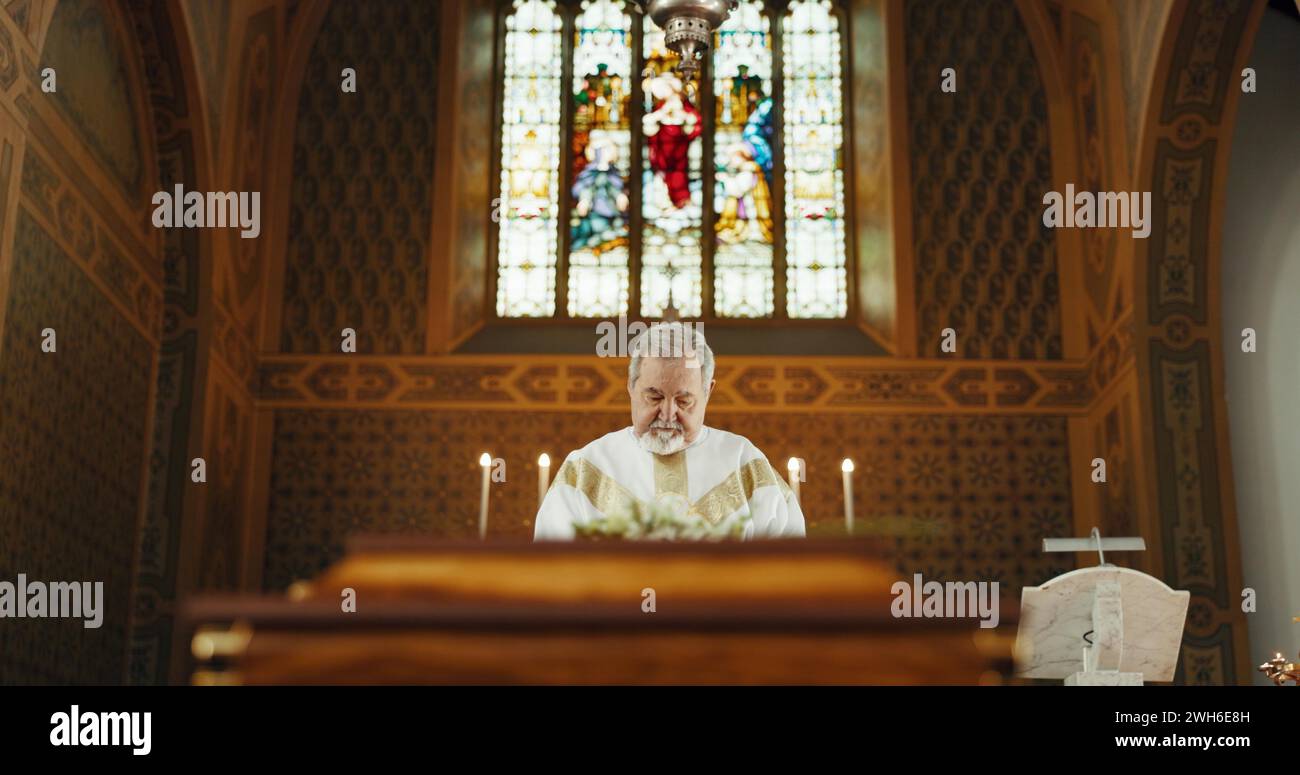 Funeral, church and priest with prayer by coffin for memorial service ...