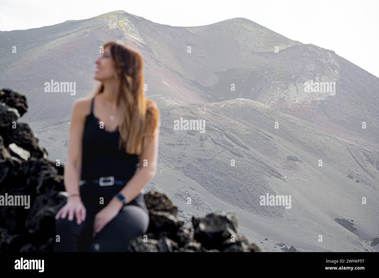 woman looks at the sky smiling in front of a volcano Stock Photo - Alamy