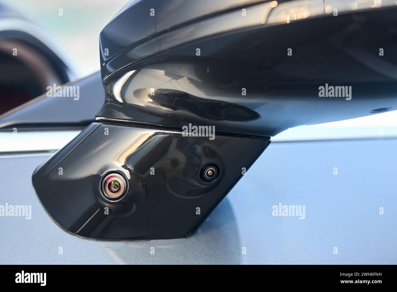 Luxury car detail left back mirror two parking cameras closeup. Road ...