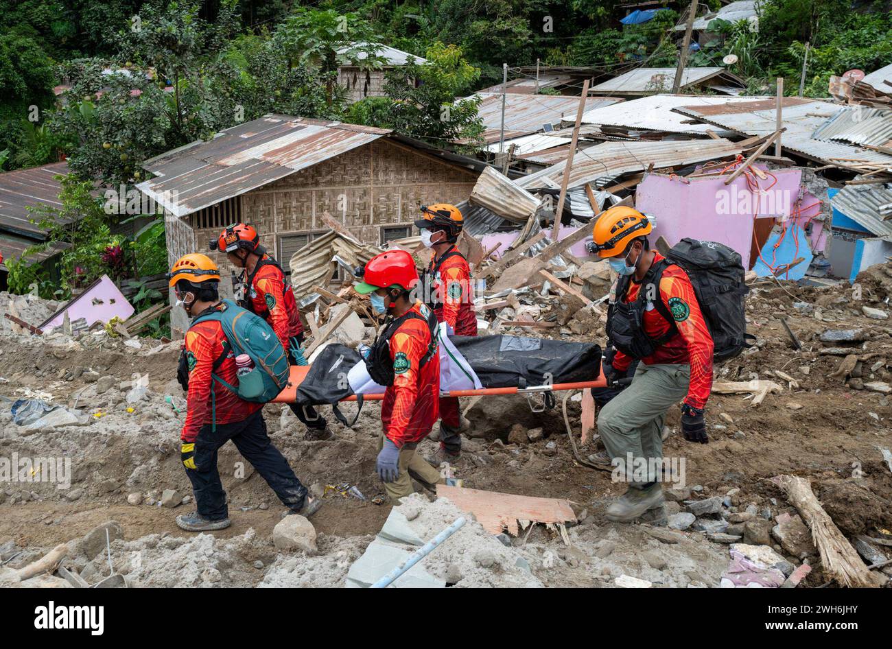 Rescuers carry a body from the landslide-hit village of Masara in Maco, Davao de Oro province ...