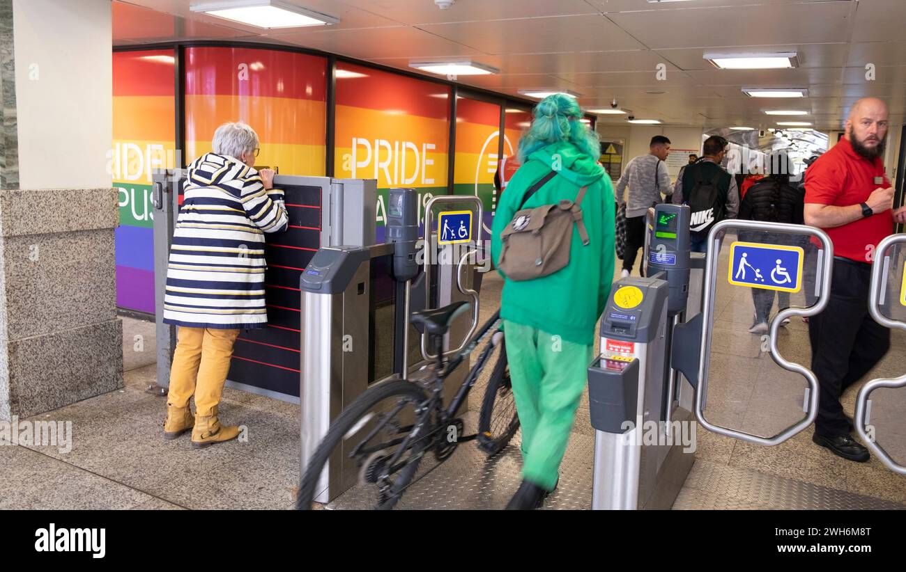 Rear back view woman wearing green with bike passing through Cardiff ...