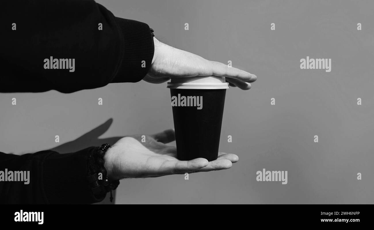 Hand taking a cup of coffee on dark background. Hot drink in take-away ...