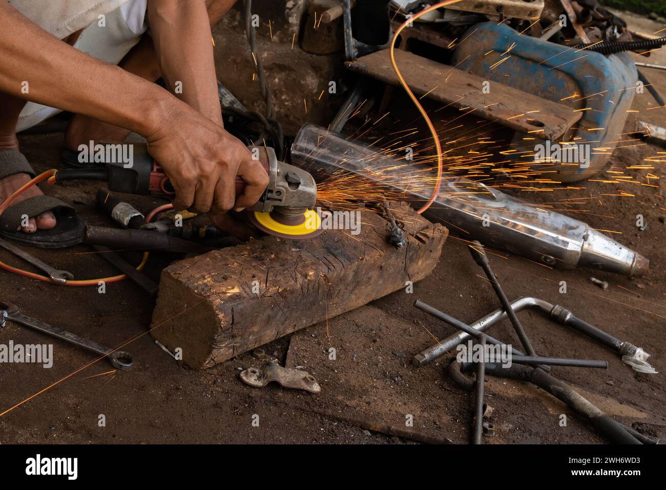A welder cutting metal with a grinder prepares to weld Stock Photo - Alamy