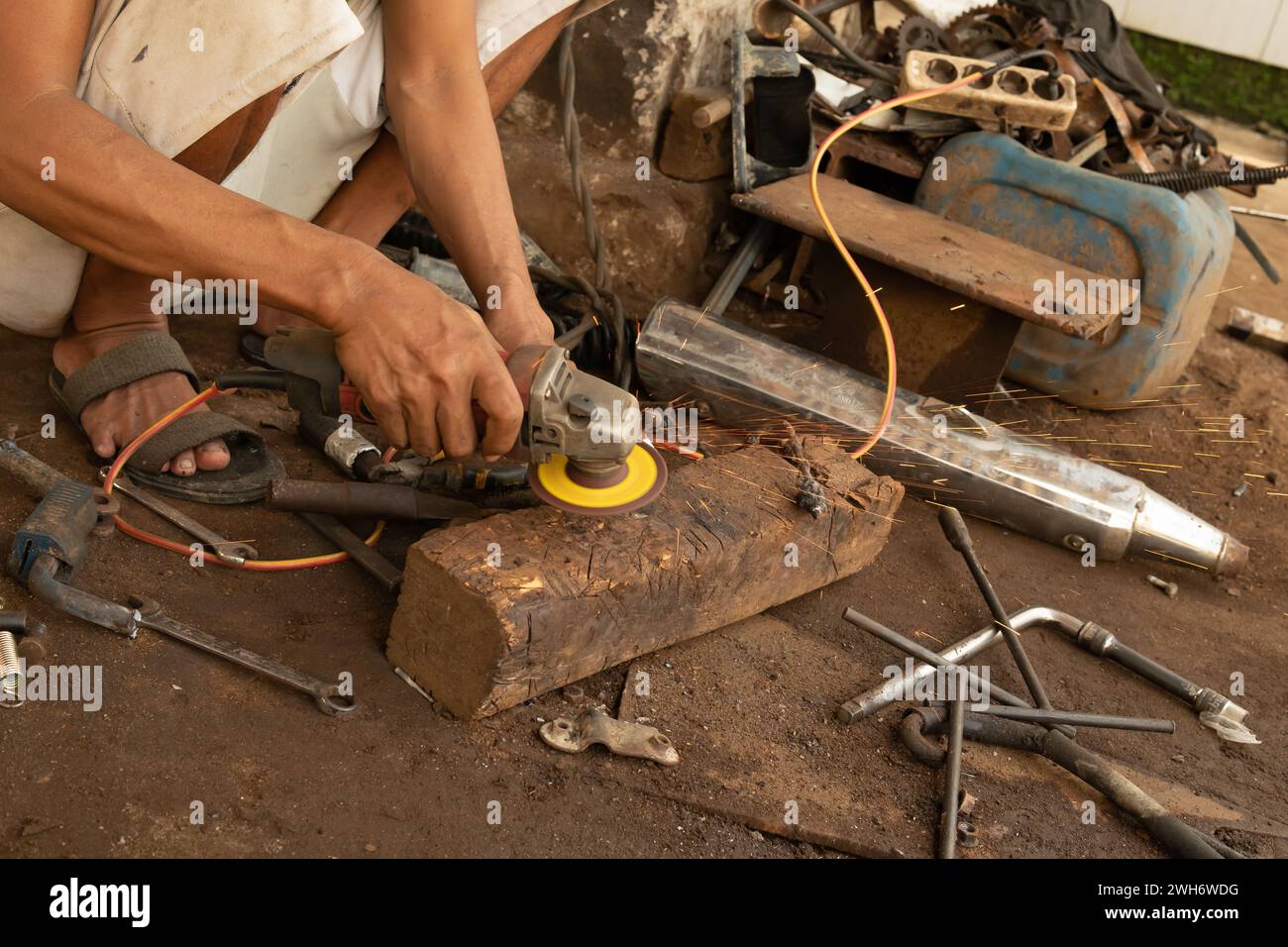 A welder cutting metal with a grinder prepares to weld Stock Photo - Alamy