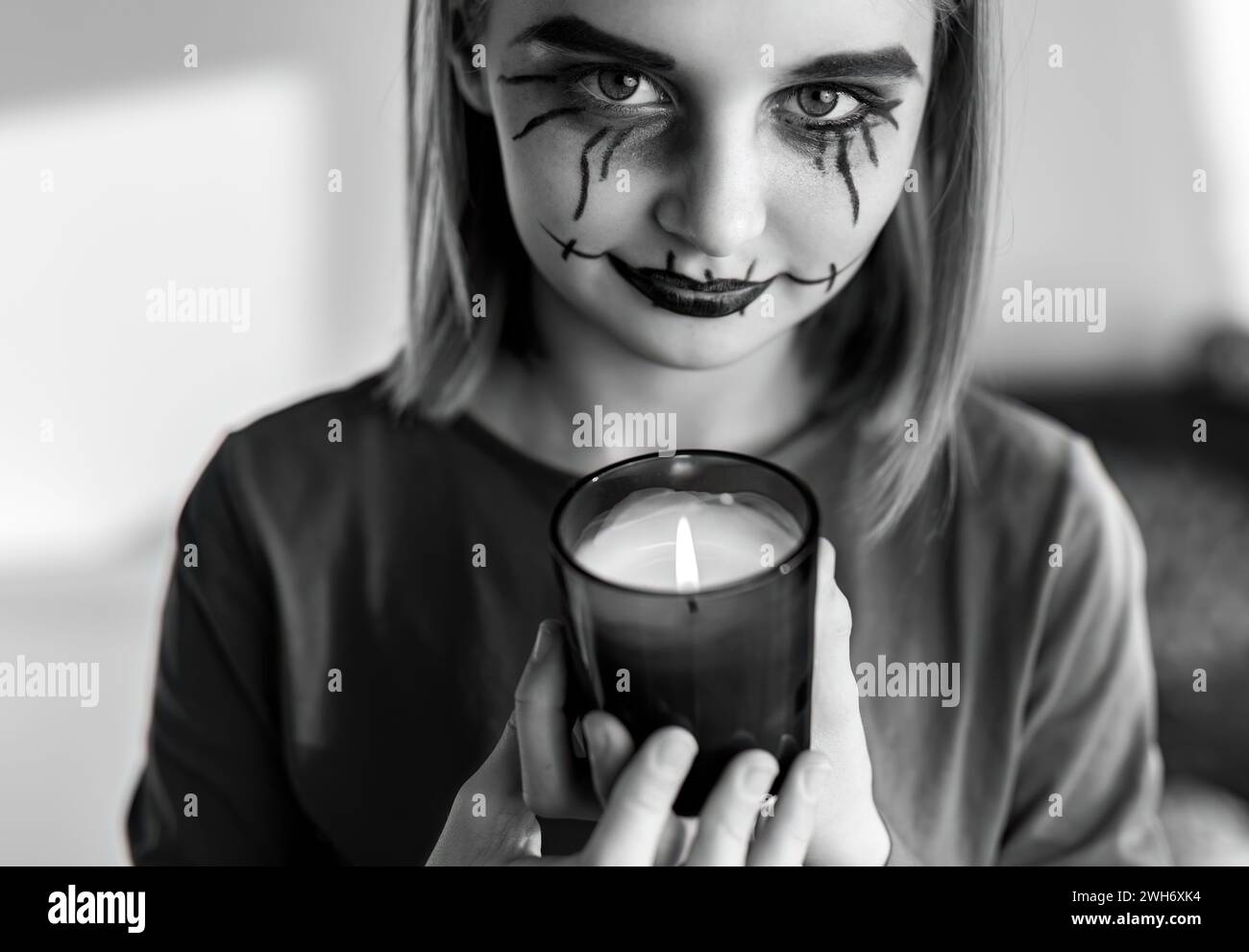 Preteen girl with spooky Halloween makeup posing at camera with ...
