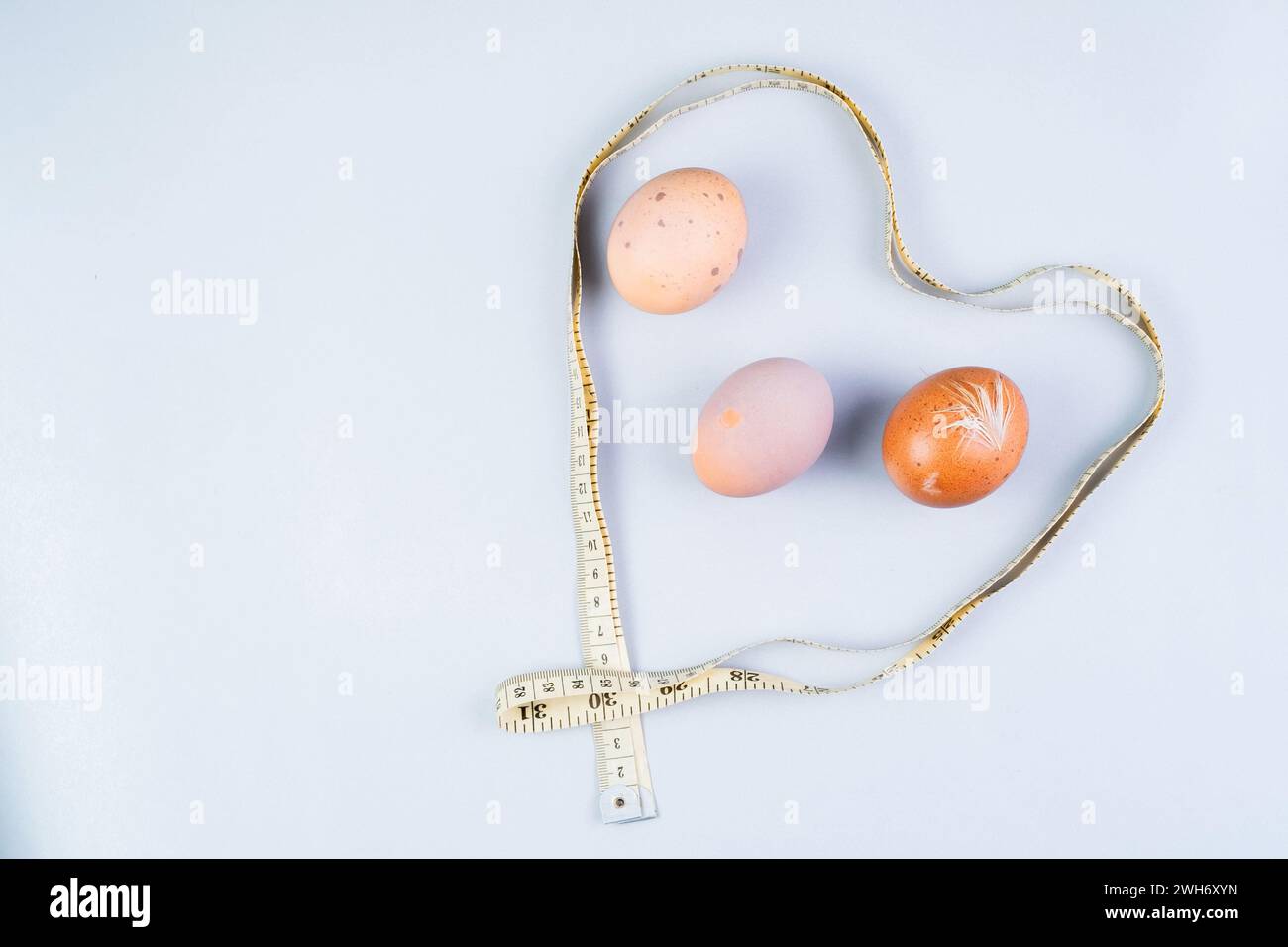 Chicken eggs and measuring tape, healthy diet concept on white ...