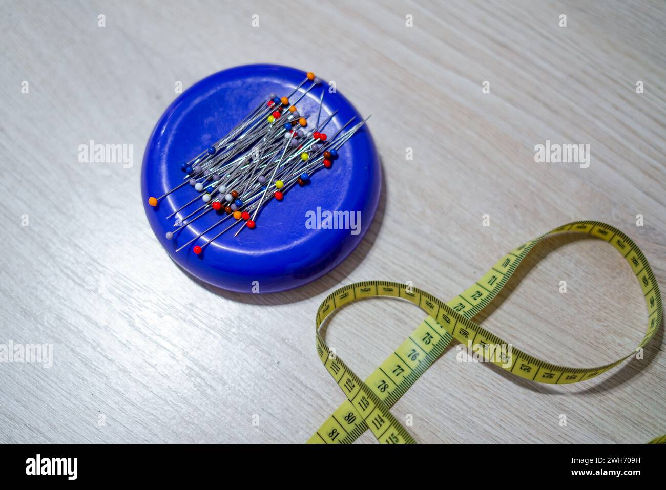 Colorful pins and a measuring tape in the sewing studio Stock Photo - Alamy