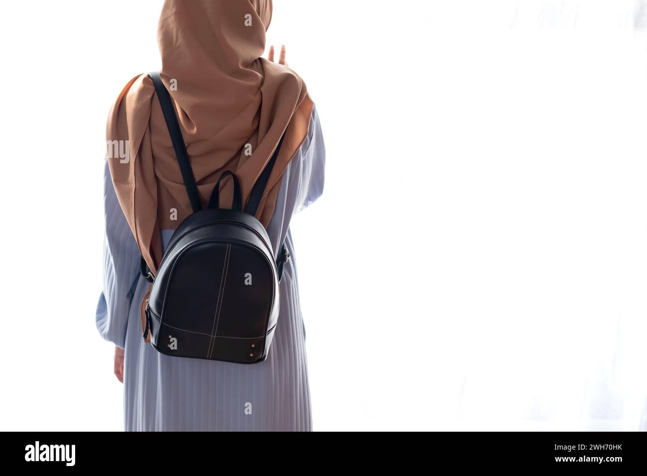 Muslim woman standing with sling bag on white background. Travel ...