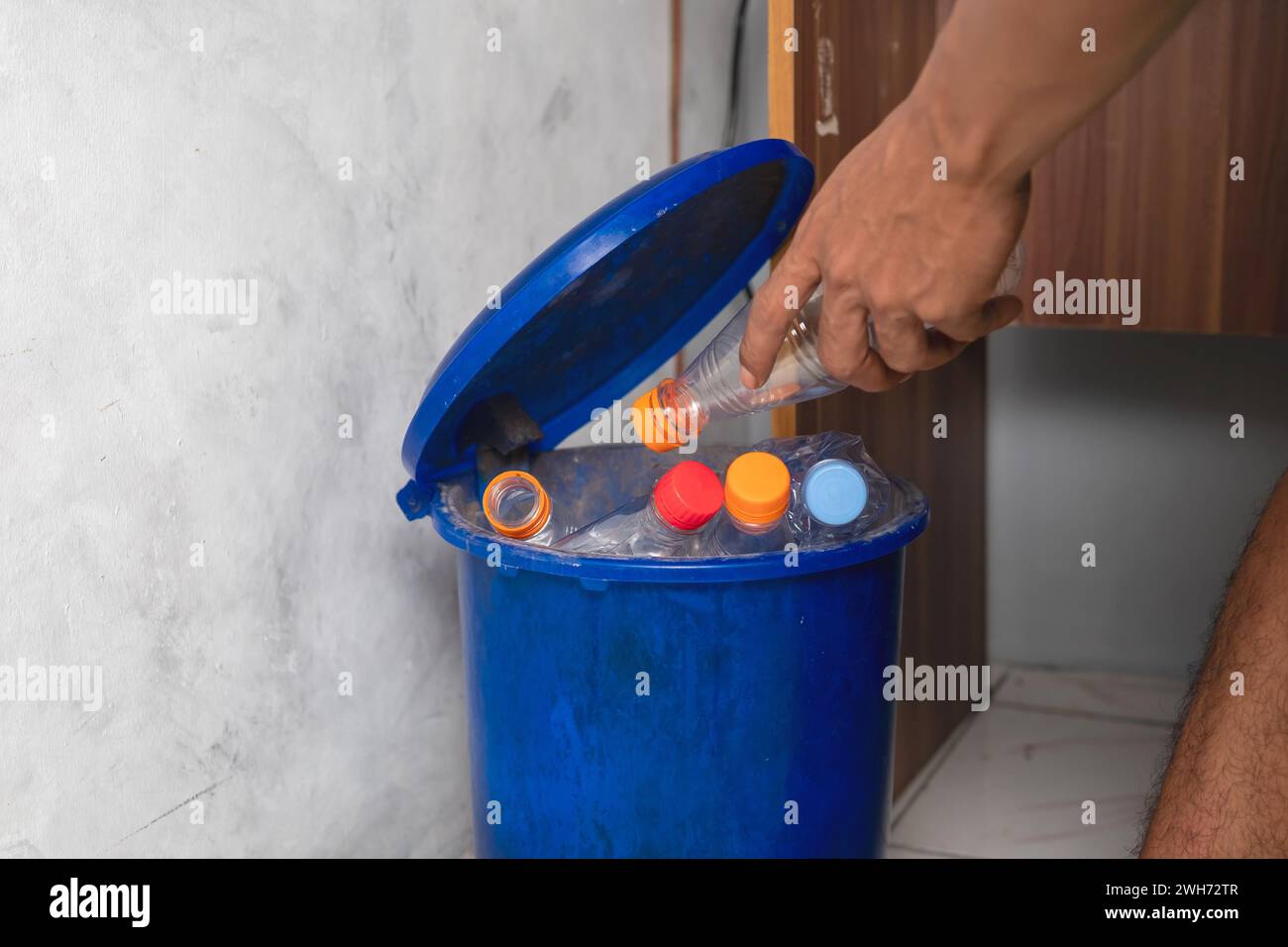 Male hand throwing trash empty plastic bottles into recycling bin Stock ...