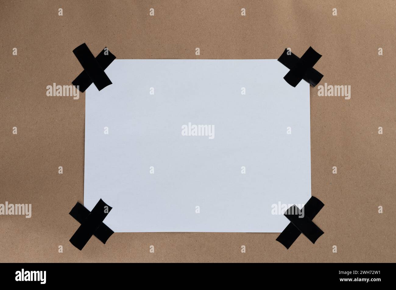 White paper sheet attached with black tape to brown background Stock ...