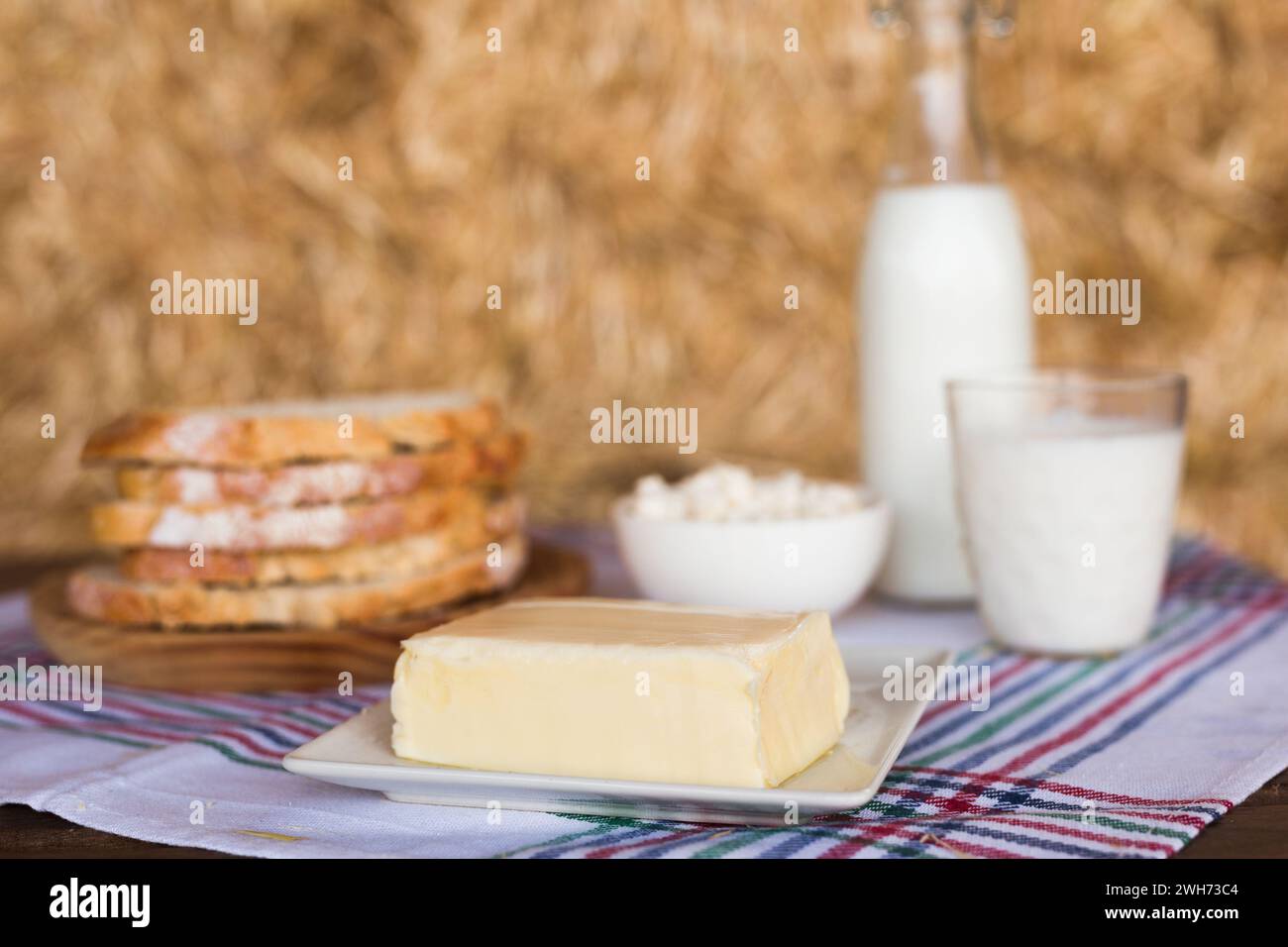 Butter, milk, cottage cheese, bread on the table in the barn against ...