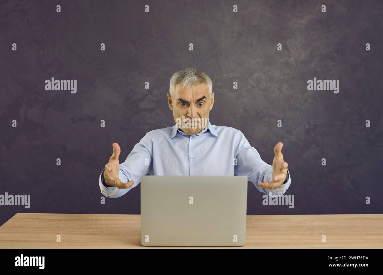 Outraged and angry man looking at screen reading bad news or having ...