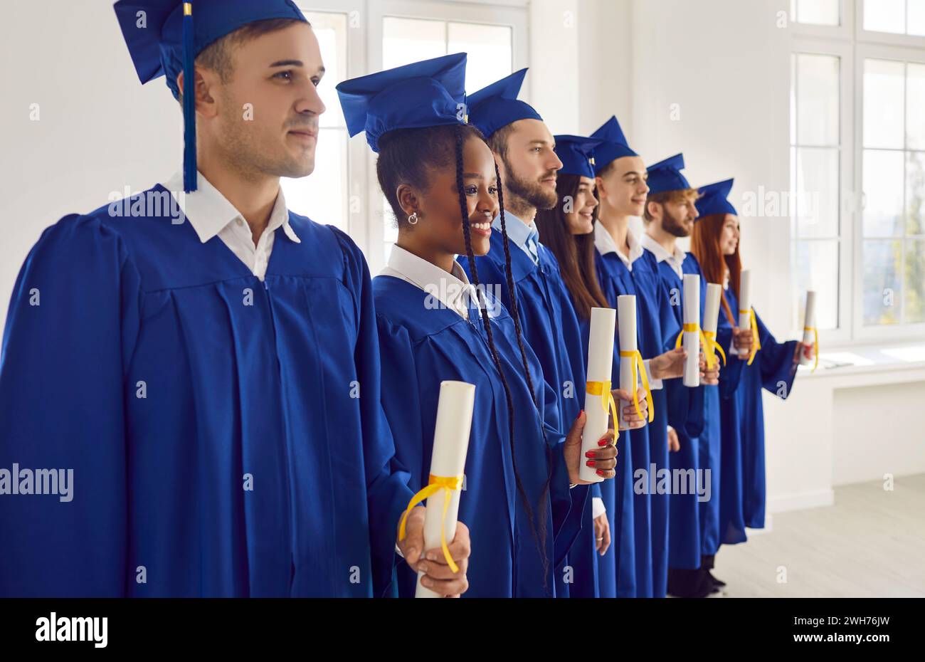 Happy diverse college or university students in caps and gowns at ...