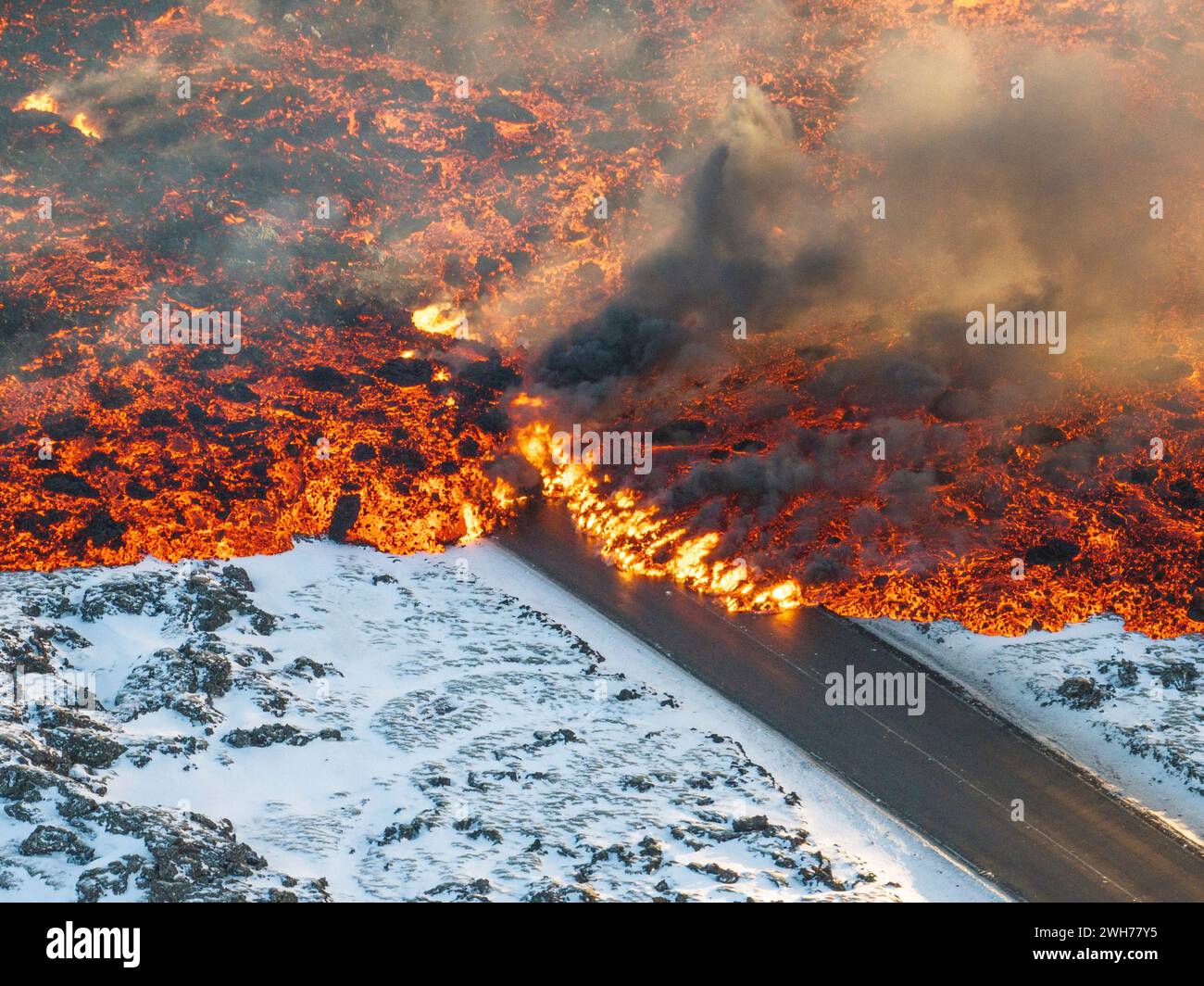Lava crosses the main road to Grindavík and flows on the road leading ...