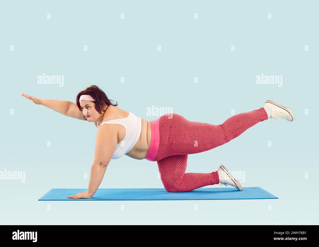 Young overweight woman doing plank exercise during her weight loss ...