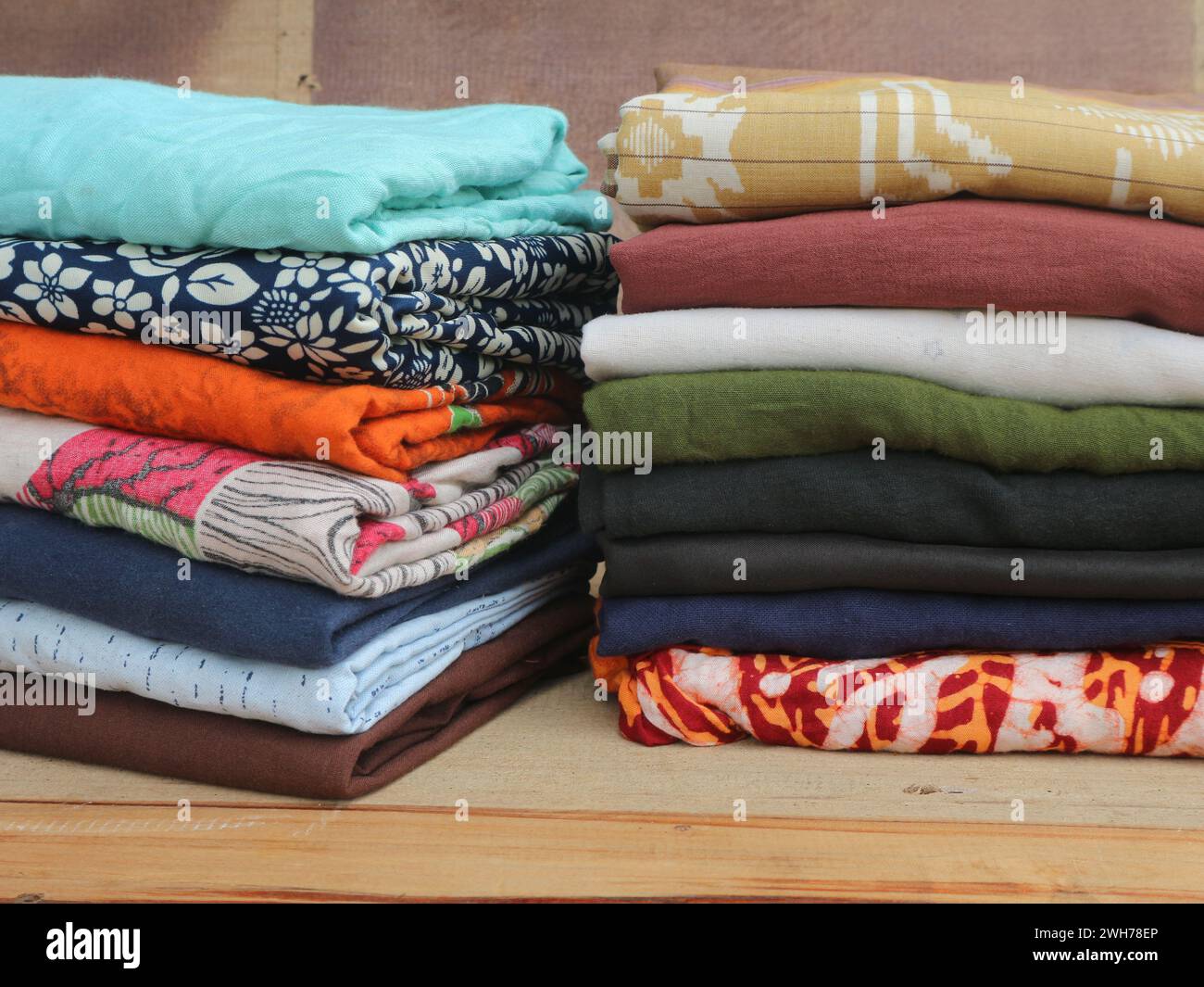 Folded cloth in piles, various types of clean clothes arranged neatly ...