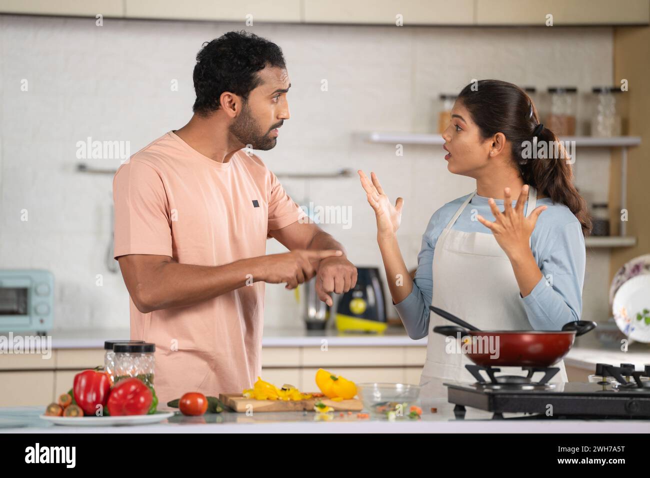 Indian Angry Husband arguing with wife while cooking at kitchen due to ...