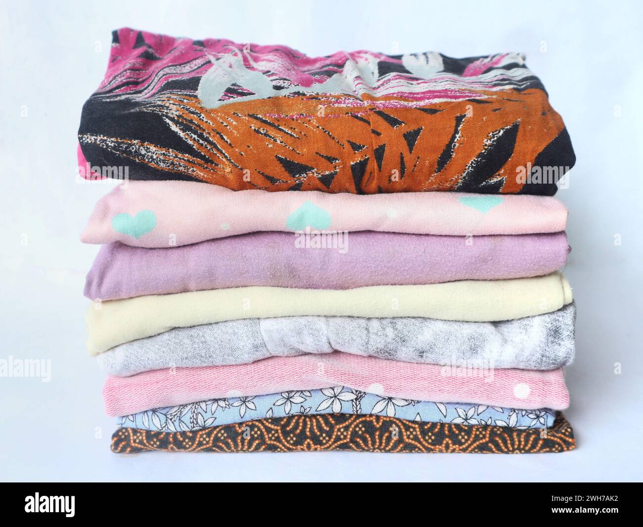 Pile of clean clothes neatly arranged isolated on white background ...