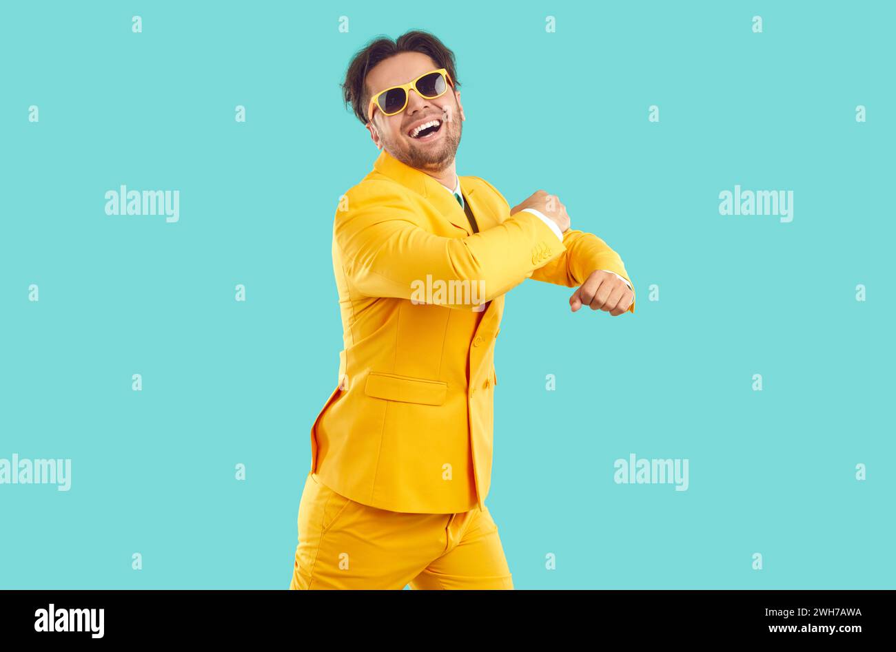 Happy joyful young man dancing on light blue background Stock Photo - Alamy