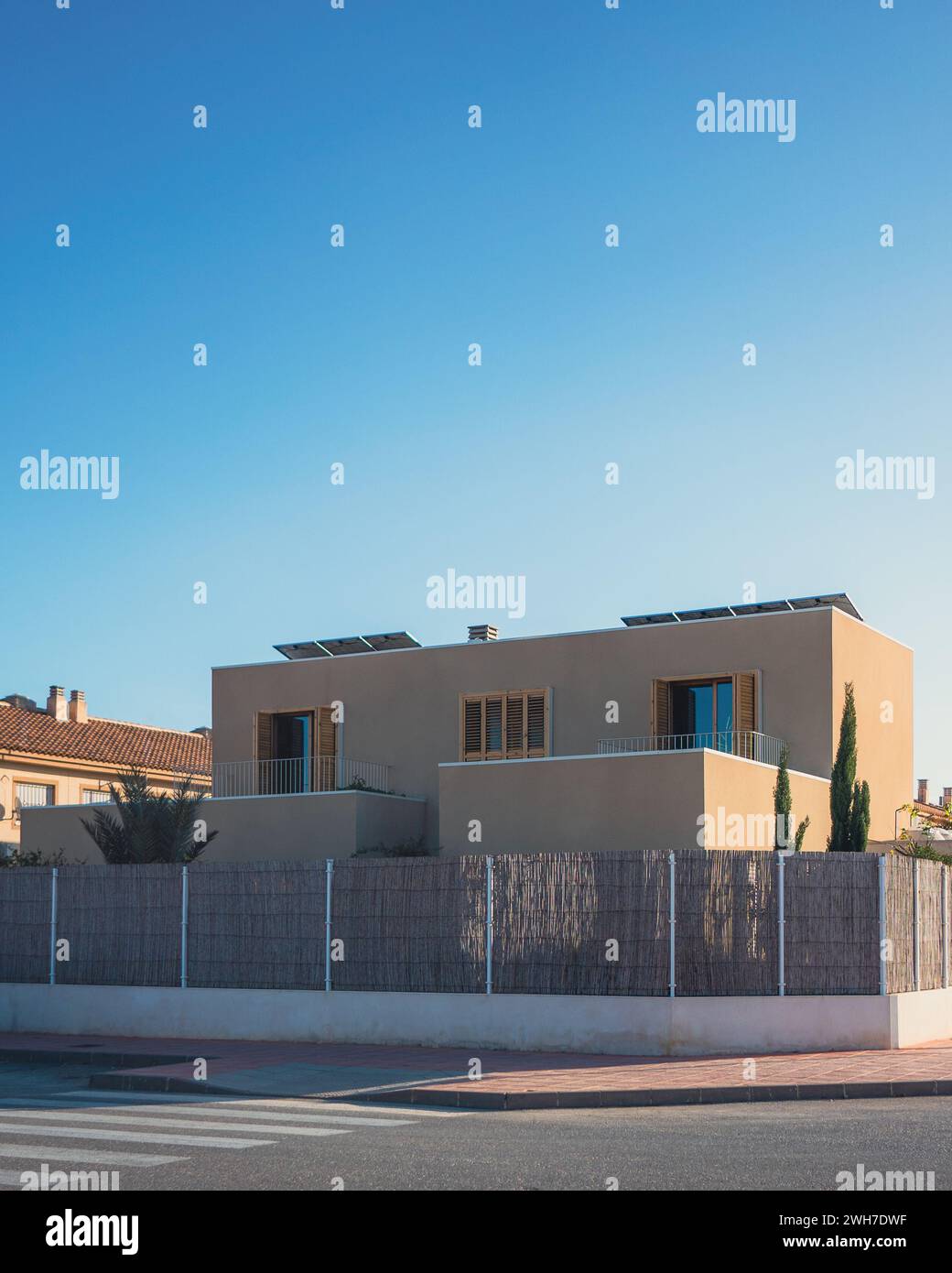 Fence in front of building with adjacent houses Stock Photo - Alamy