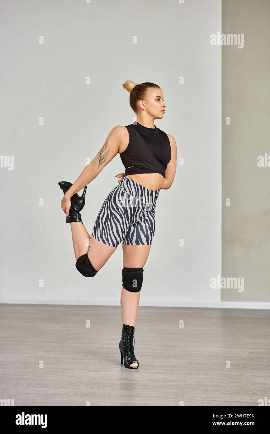 woman gracefully stretches leg in zebra shorts and high heels ...