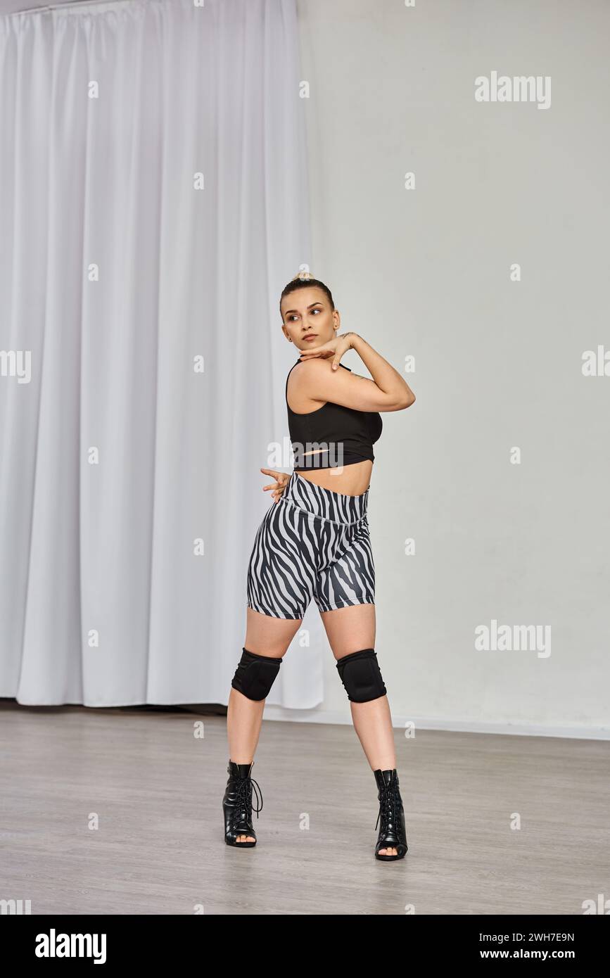dancer in high heels and zebra-print shorts dances against white wall ...
