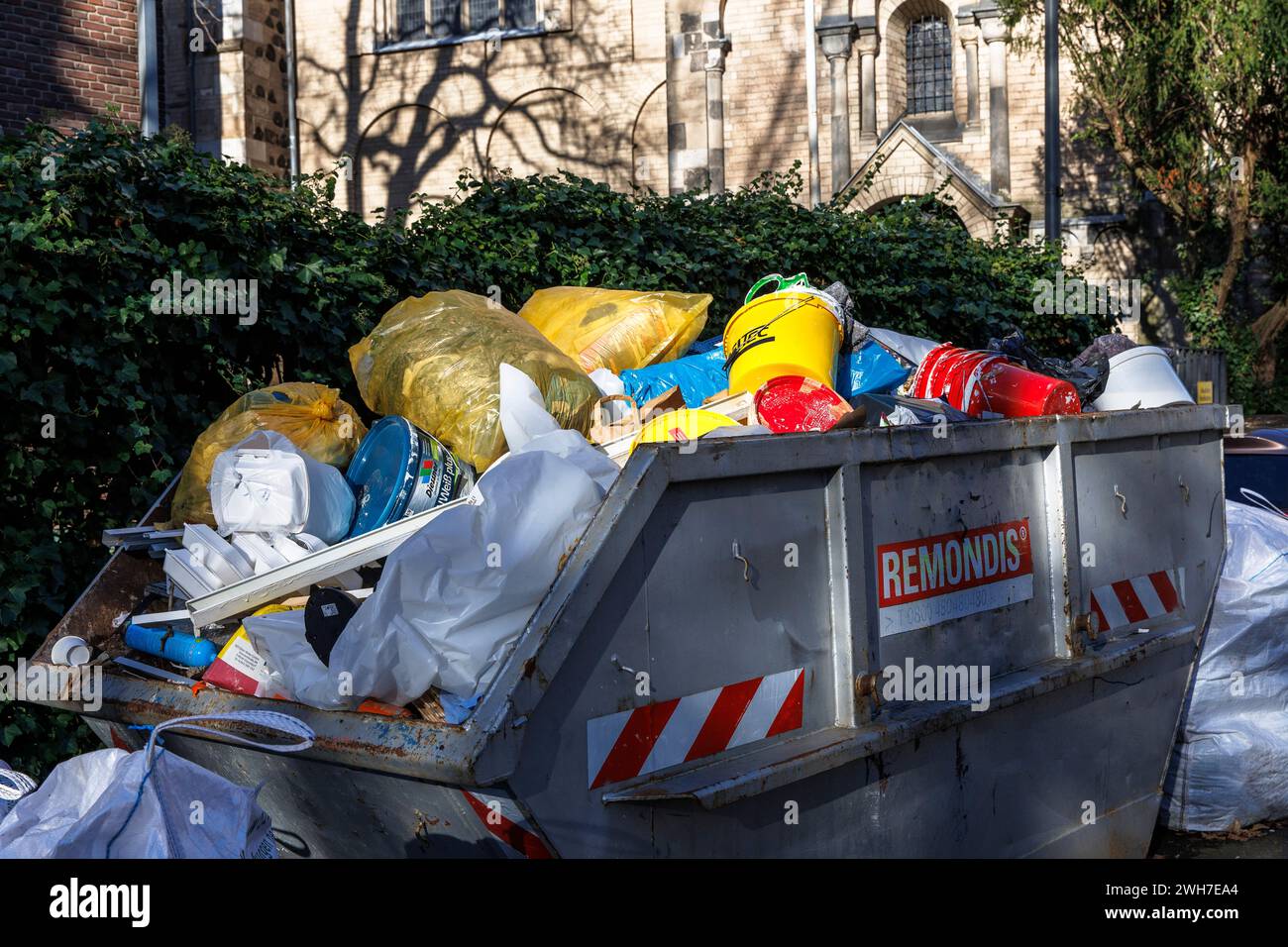 a container and heavy-duty sacks of construction waste are standing in ...
