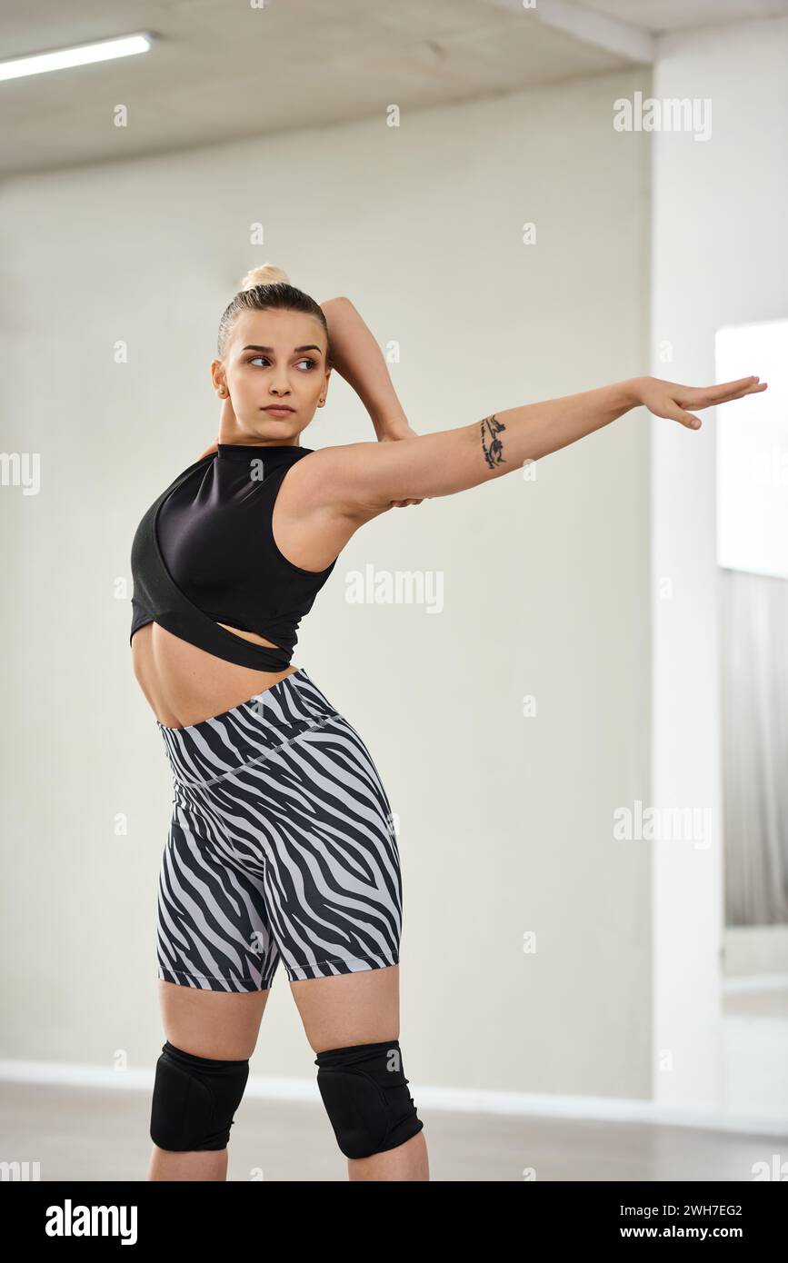 A graceful dancer stretches her body and arms in vibrant zebra shorts ...