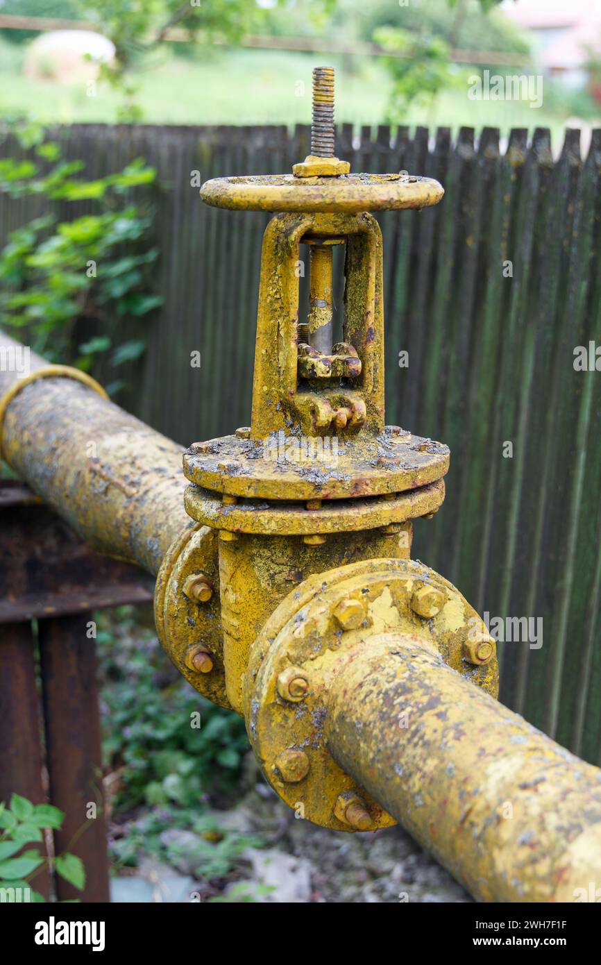 Gas pipe with big old valve-crane. Industrial gas pipeline laid along ...