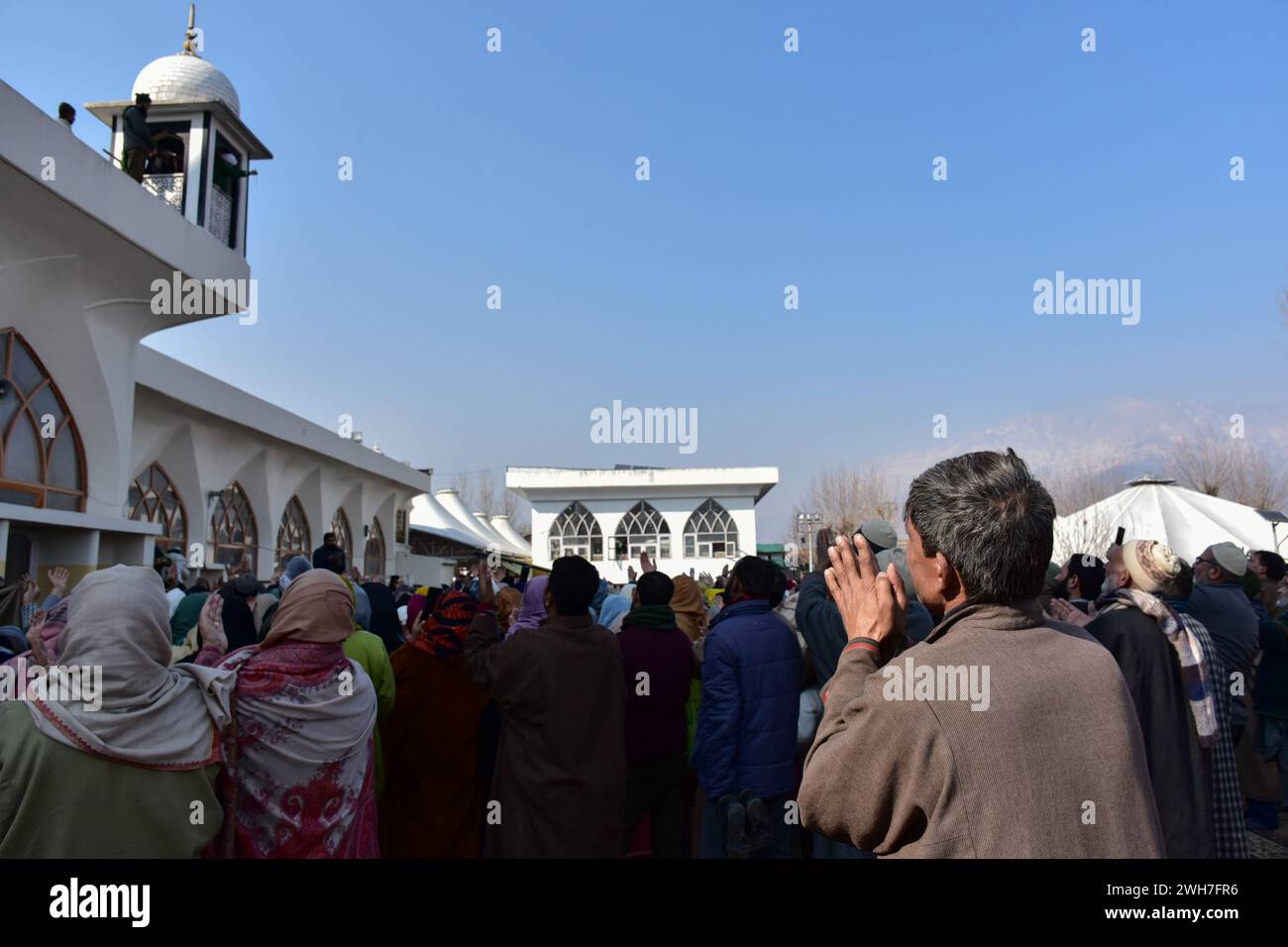 A Muslim devotee prays upon seeing a relic believed to be a hair from ...