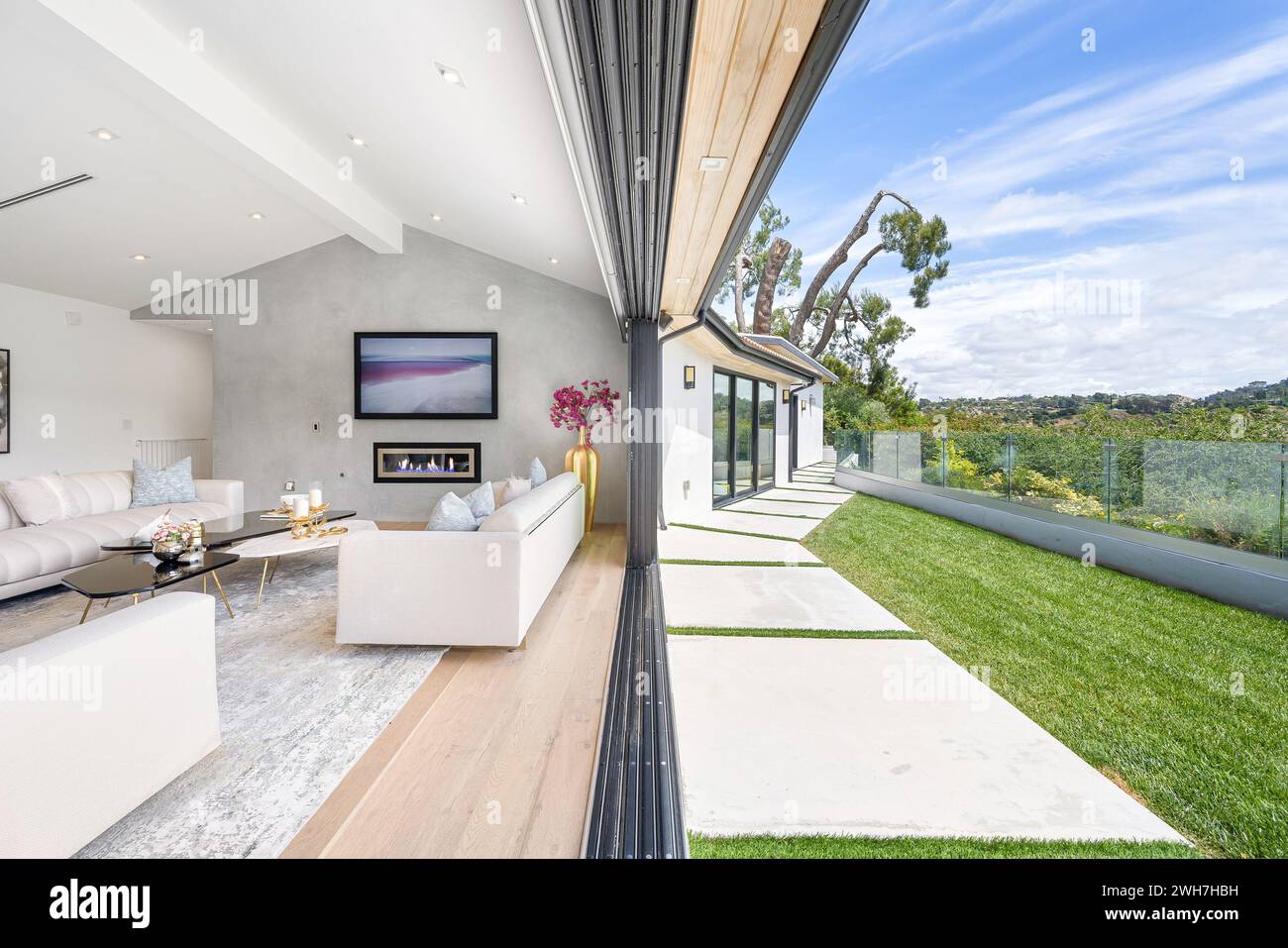 A modern living room with floor-to-ceiling glass walls and a spacious ...