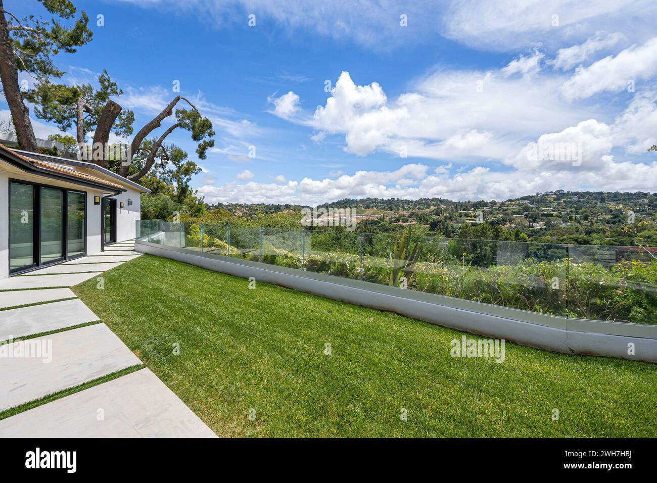 A charming house nestled alongside a lush, grassy hillside Stock Photo ...