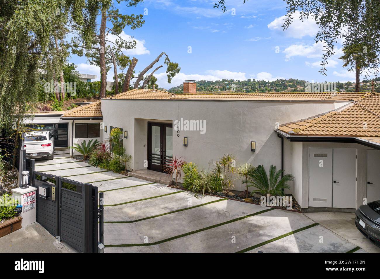 A residential house featuring a driveway with a car parked in front ...