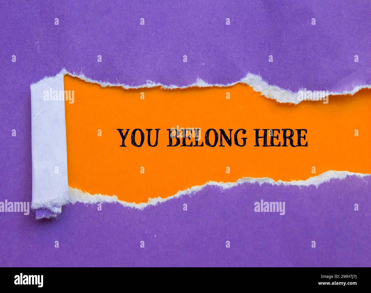 You belong here lettering on purple torn paper with orange background ...