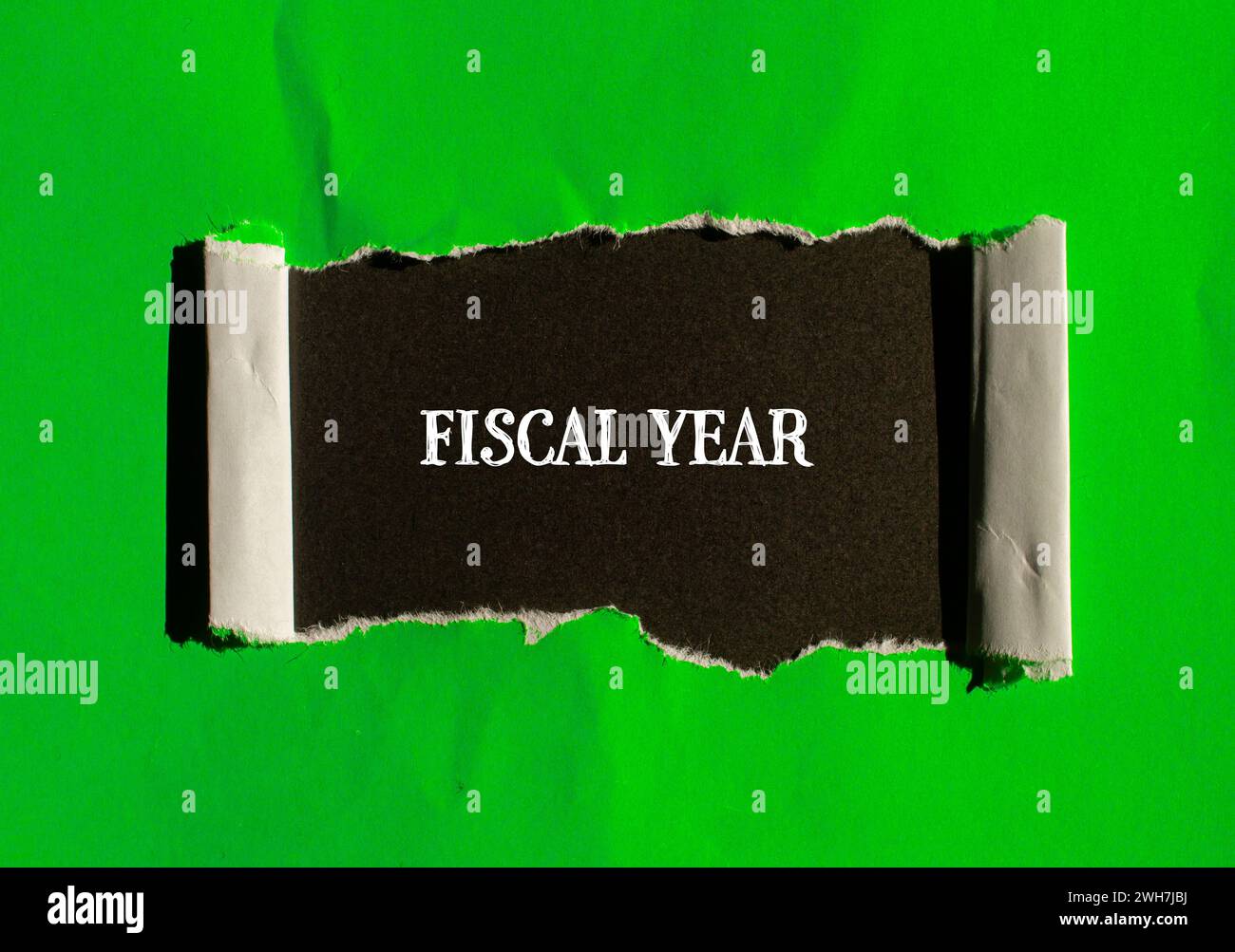 Fiscal year lettering on green torn paper with black background ...