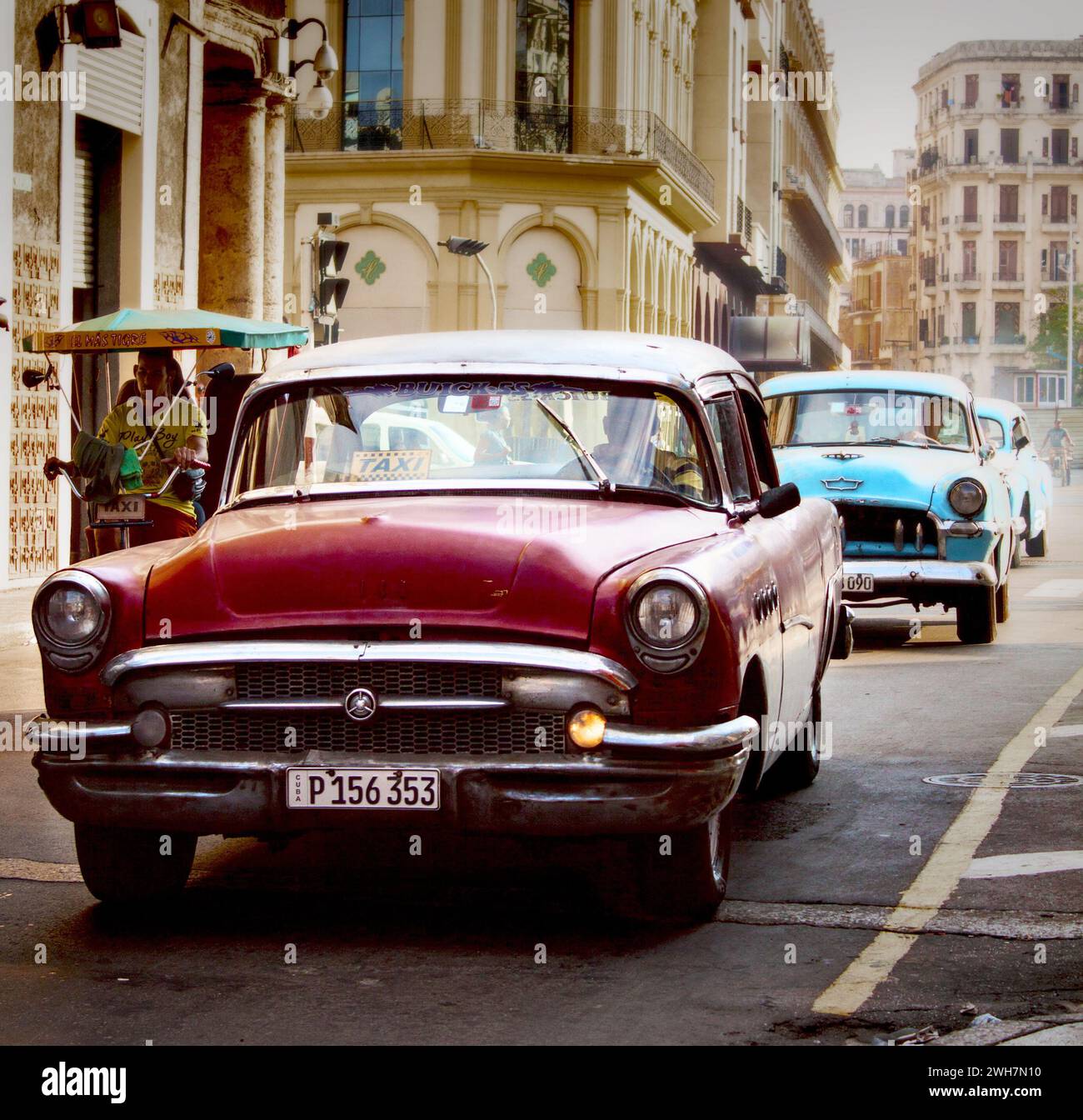 Red and blue vintage classic Cuban American cars driving through an ...
