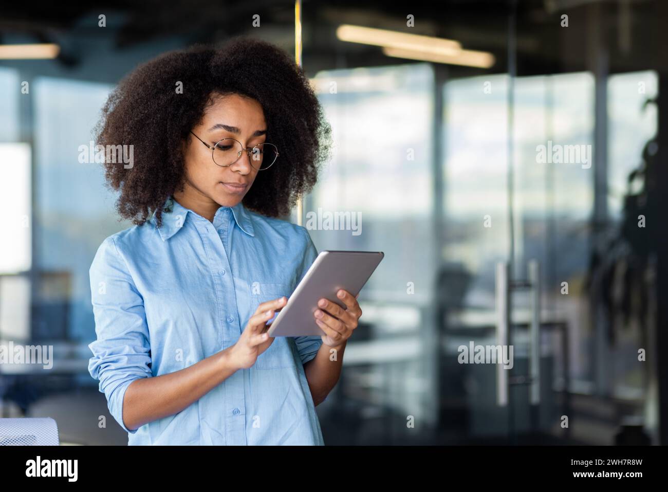 A white-collar worker is using an electric blue tablet computer in an ...