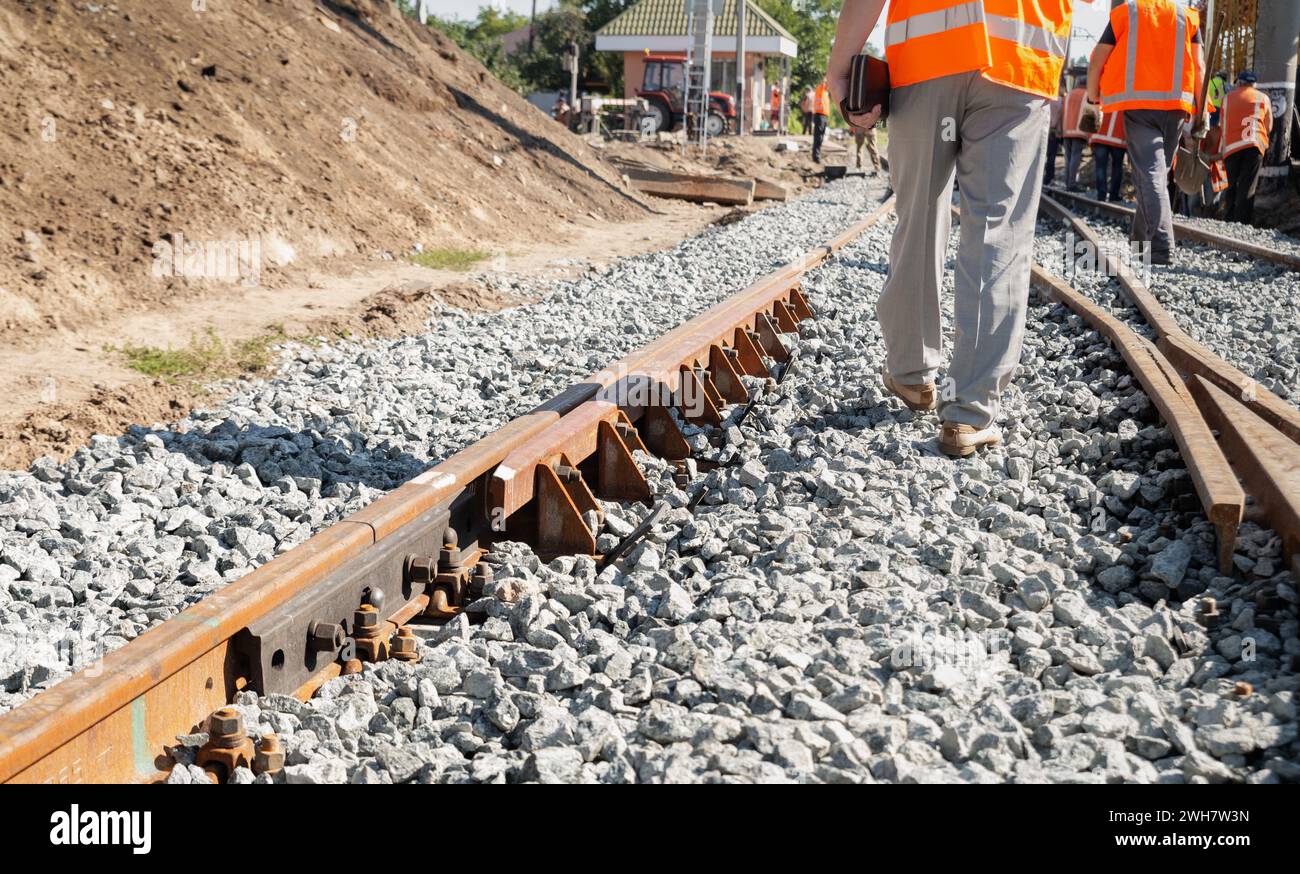 Railway repair. Uniformed workers are changing the old railway line ...