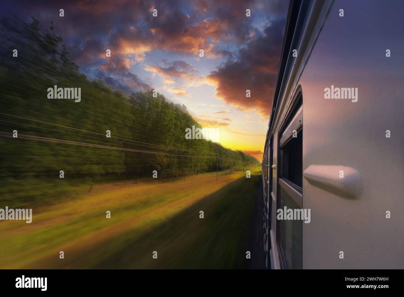Passenger train in motion with blur effect in the forest at sunset ...