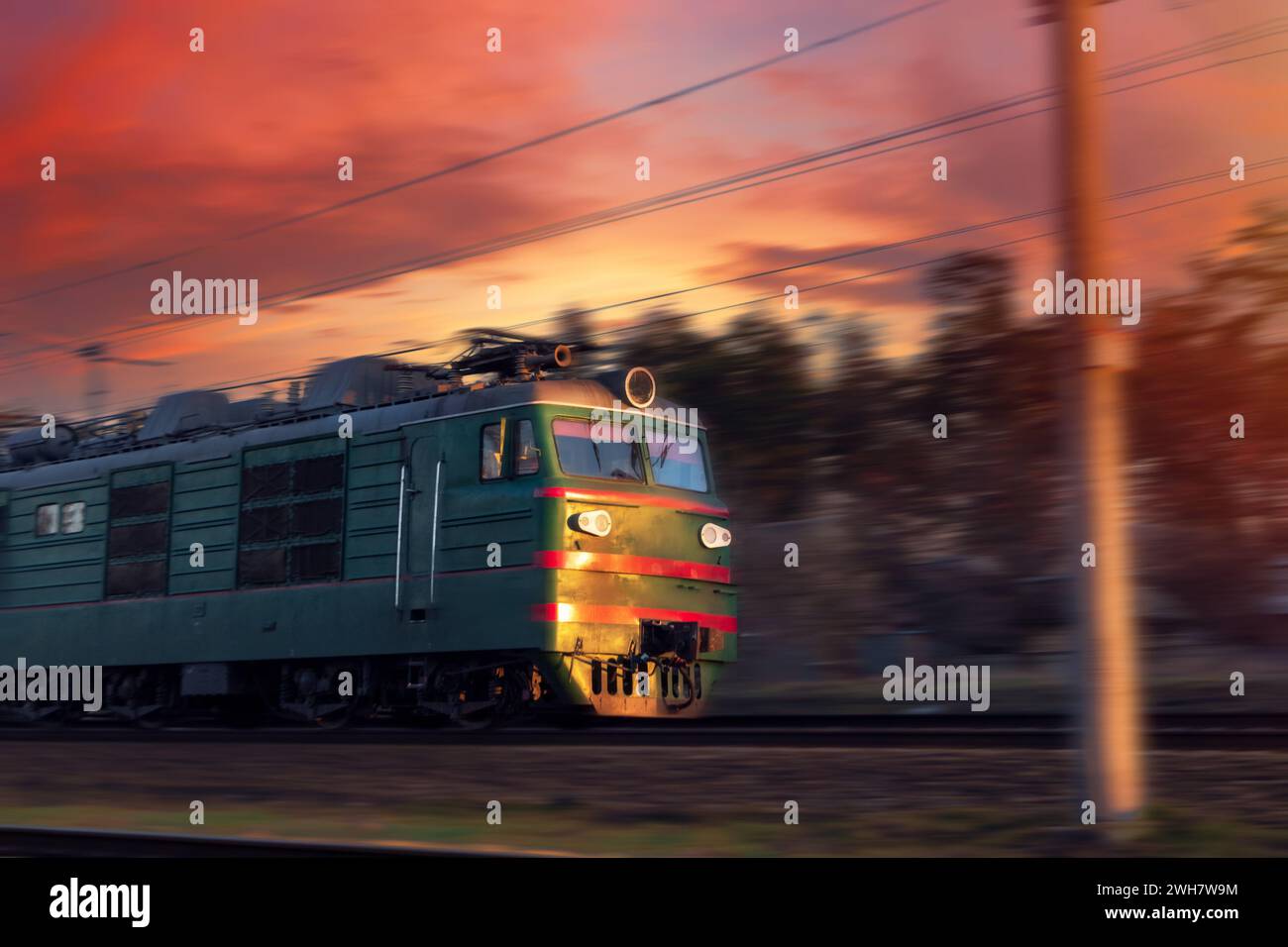 Freight train traveling by railroad with blur effect at sunset with ...