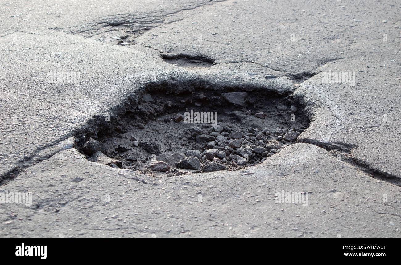 Deep pit on the road. Damaged asphalt. Bad road. Road repair Stock ...
