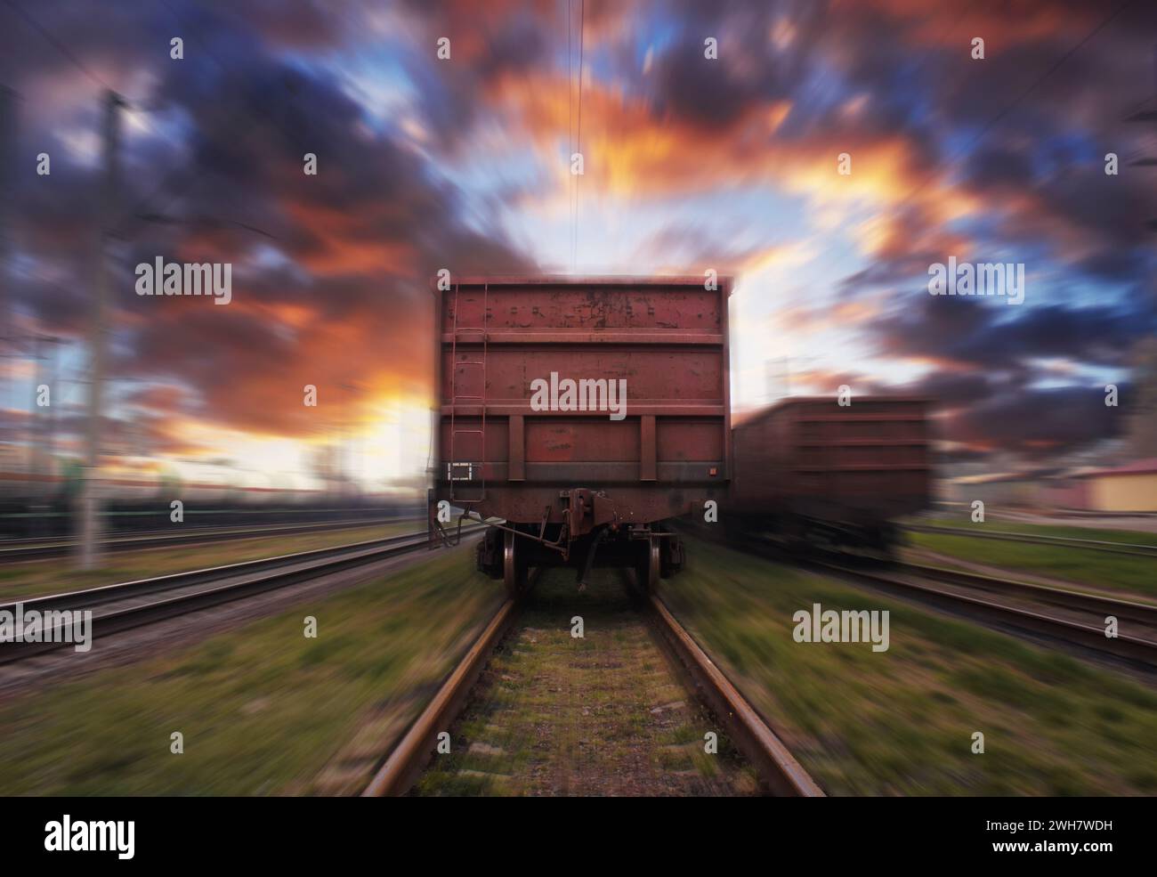 Freight train in motion with blur effect against the sunset sky with ...