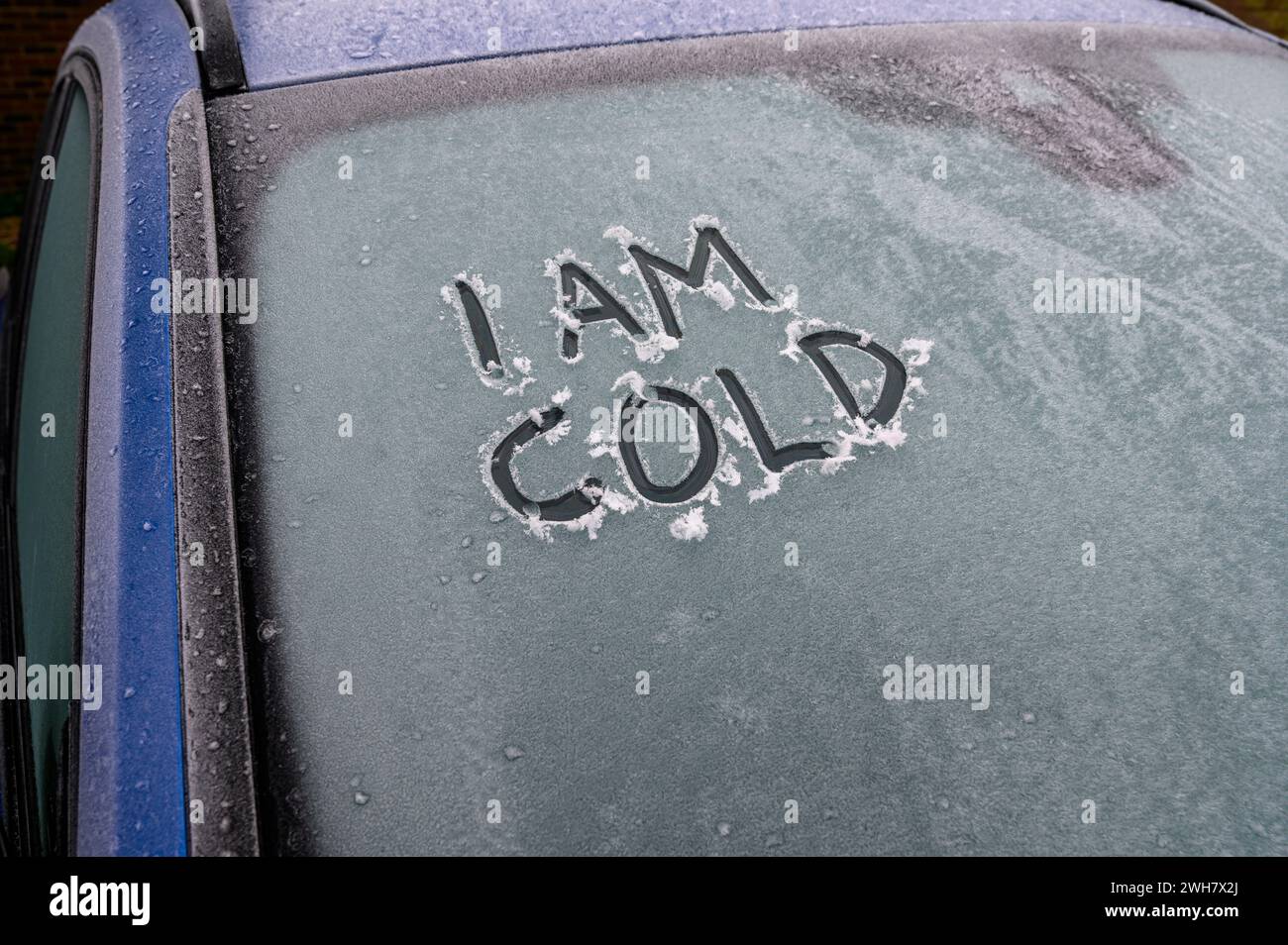 "I am cold" message written with a finger onto a frosty car windscreen ...