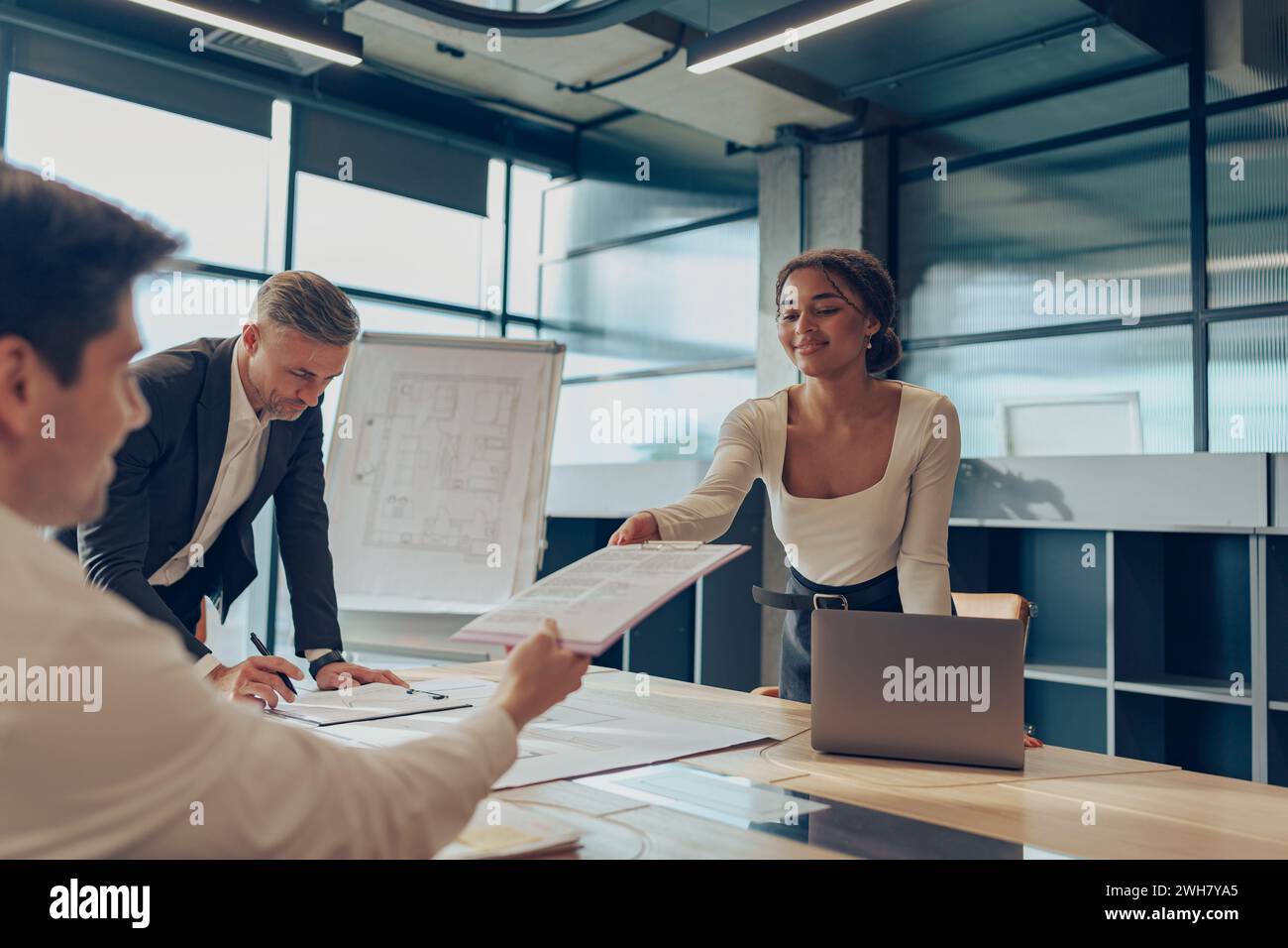 Businesswoman give handout materials to work team members during flip ...