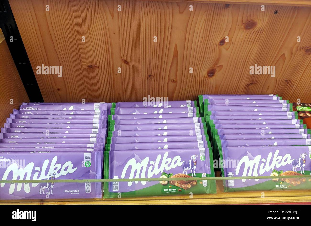 An array of Milka chocolate bars neatly organized on the shelves of a ...