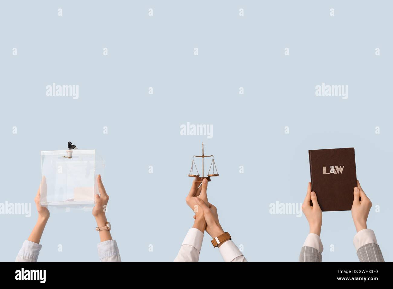 Hands holding ballot box, scales of justice and judge's gavel on light ...