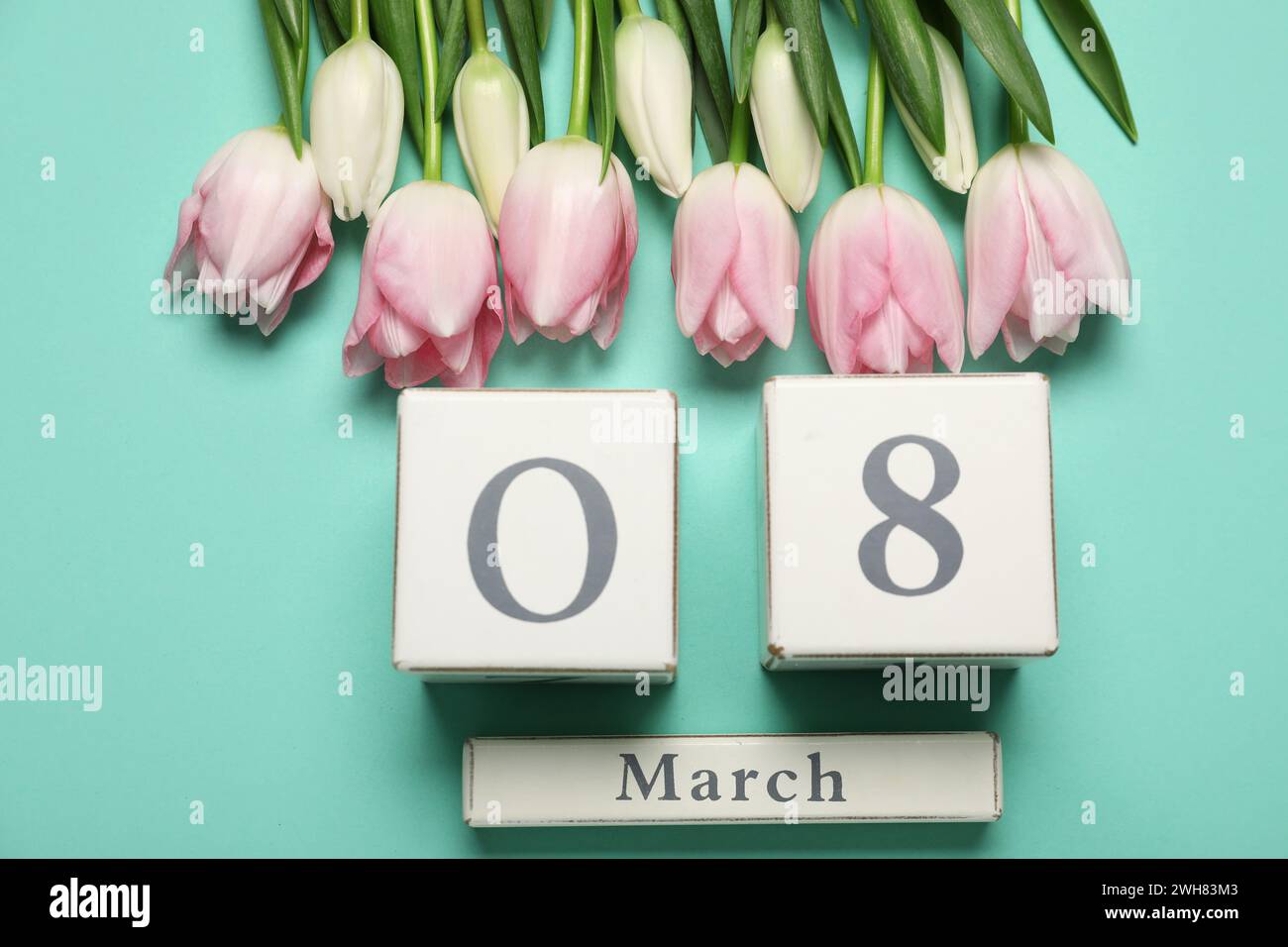 Tulip flowers and wooden calendar on turquoise background ...